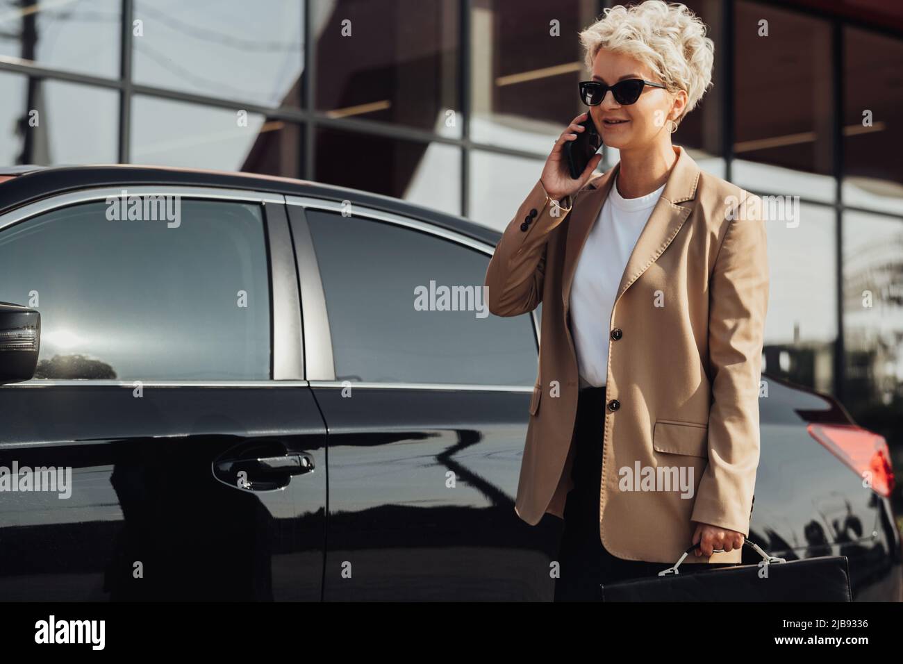Elegant Business Woman with Briefcase in Hand Talking on the Phone Near ...
