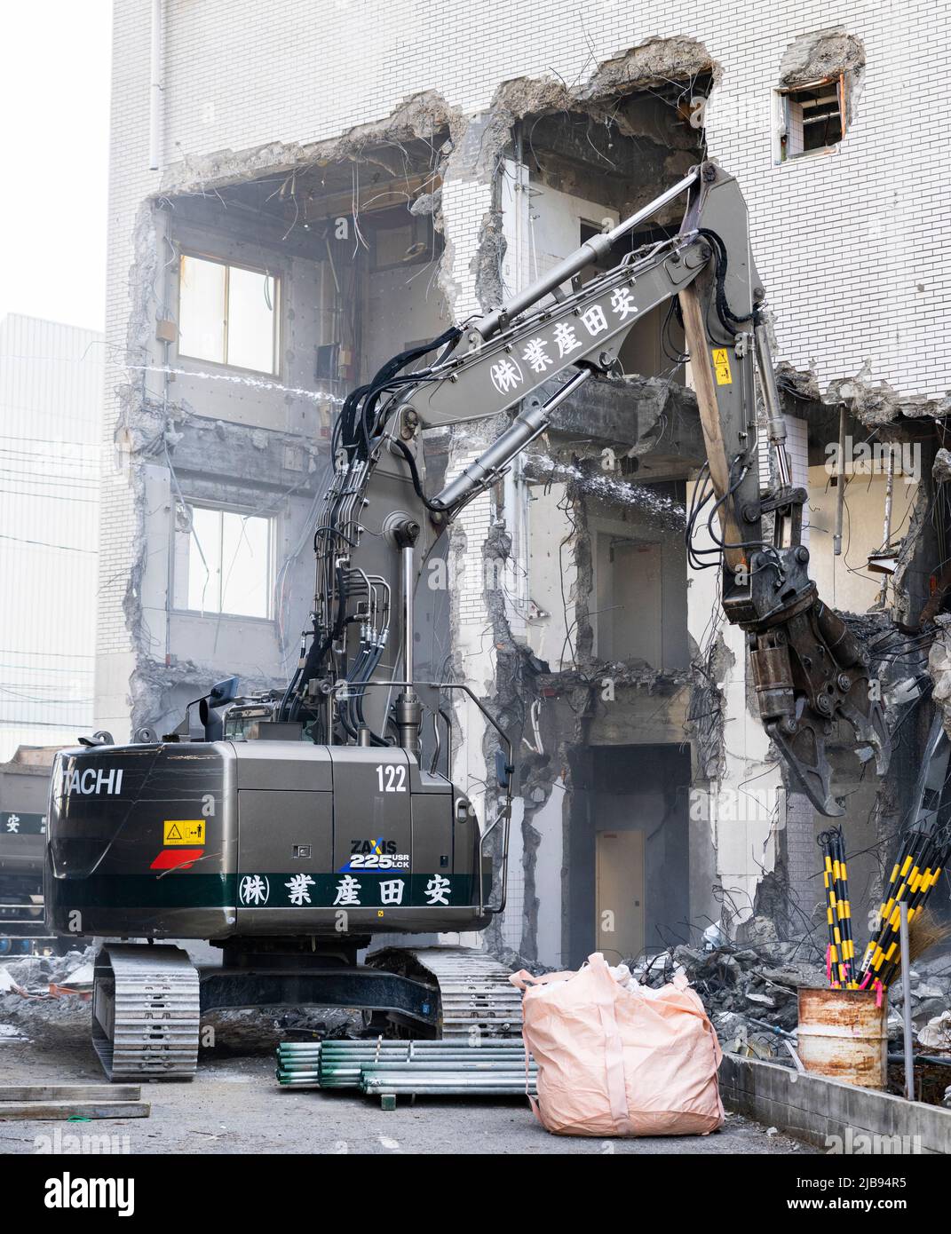 Hitachi demolition excavator with pincer demolishing building in ...