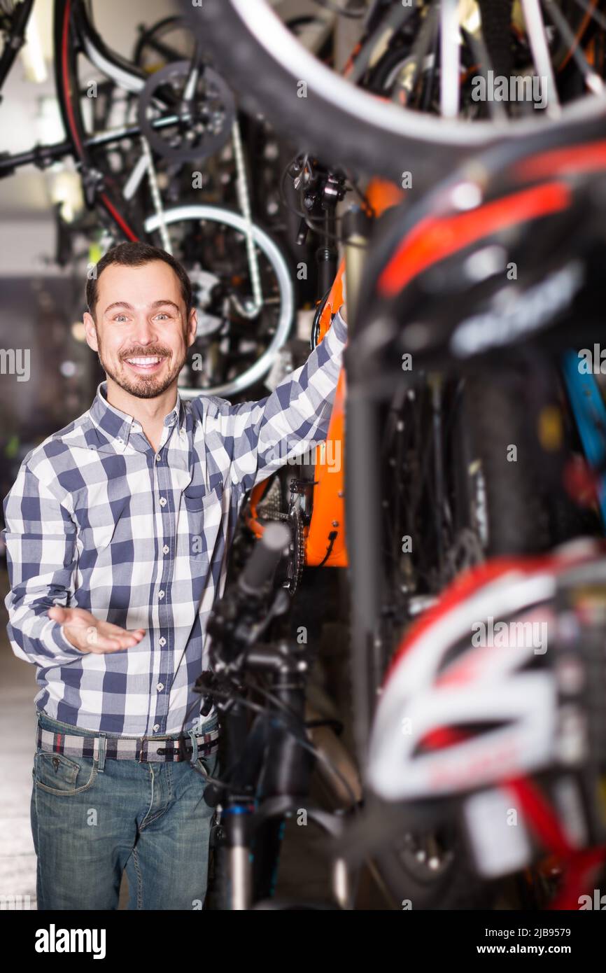 cheerful man in bicycle shop chooses for himself sports bike Stock ...