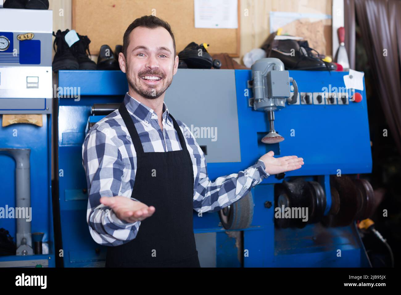 Laughing worker showing his workplace and tools Stock Photo - Alamy