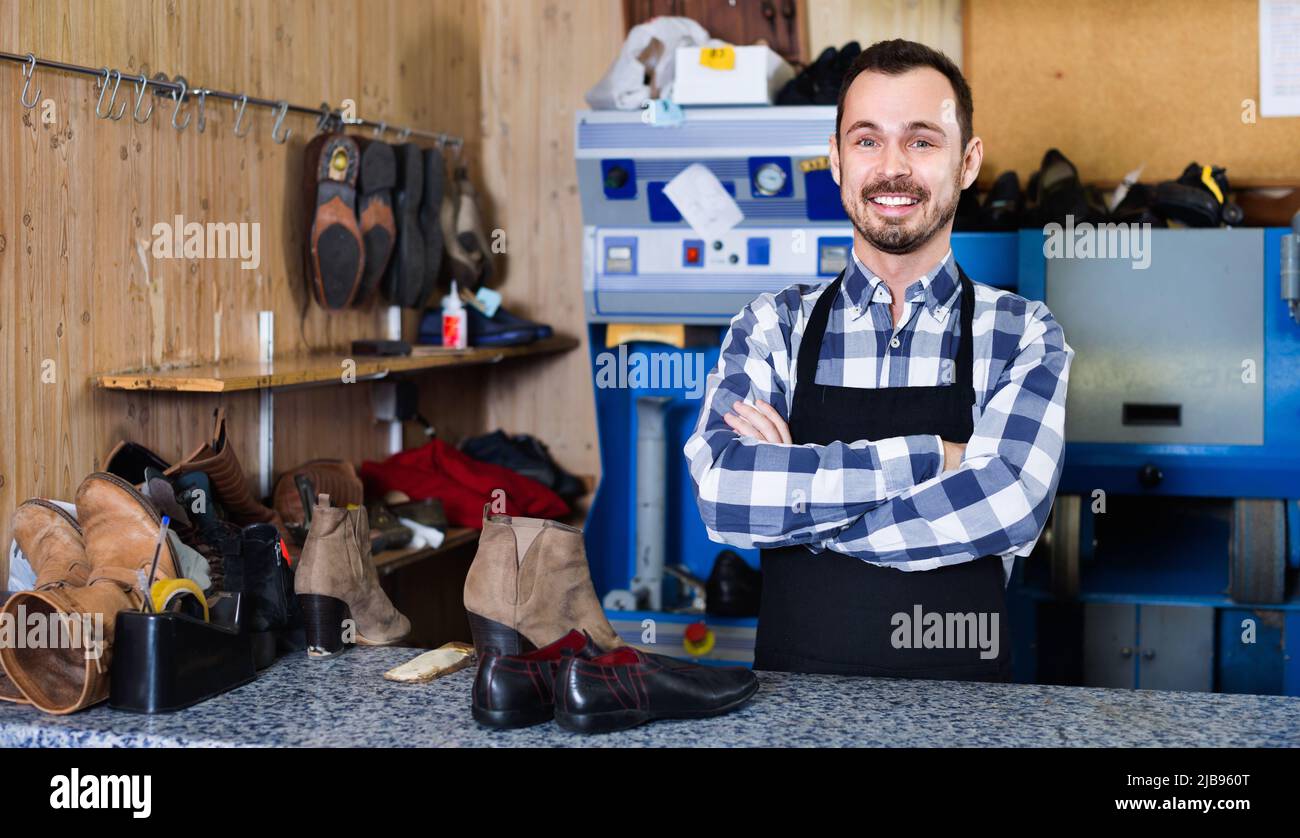 Male worker demonstrating workplace and tools in shoe Stock Photo - Alamy