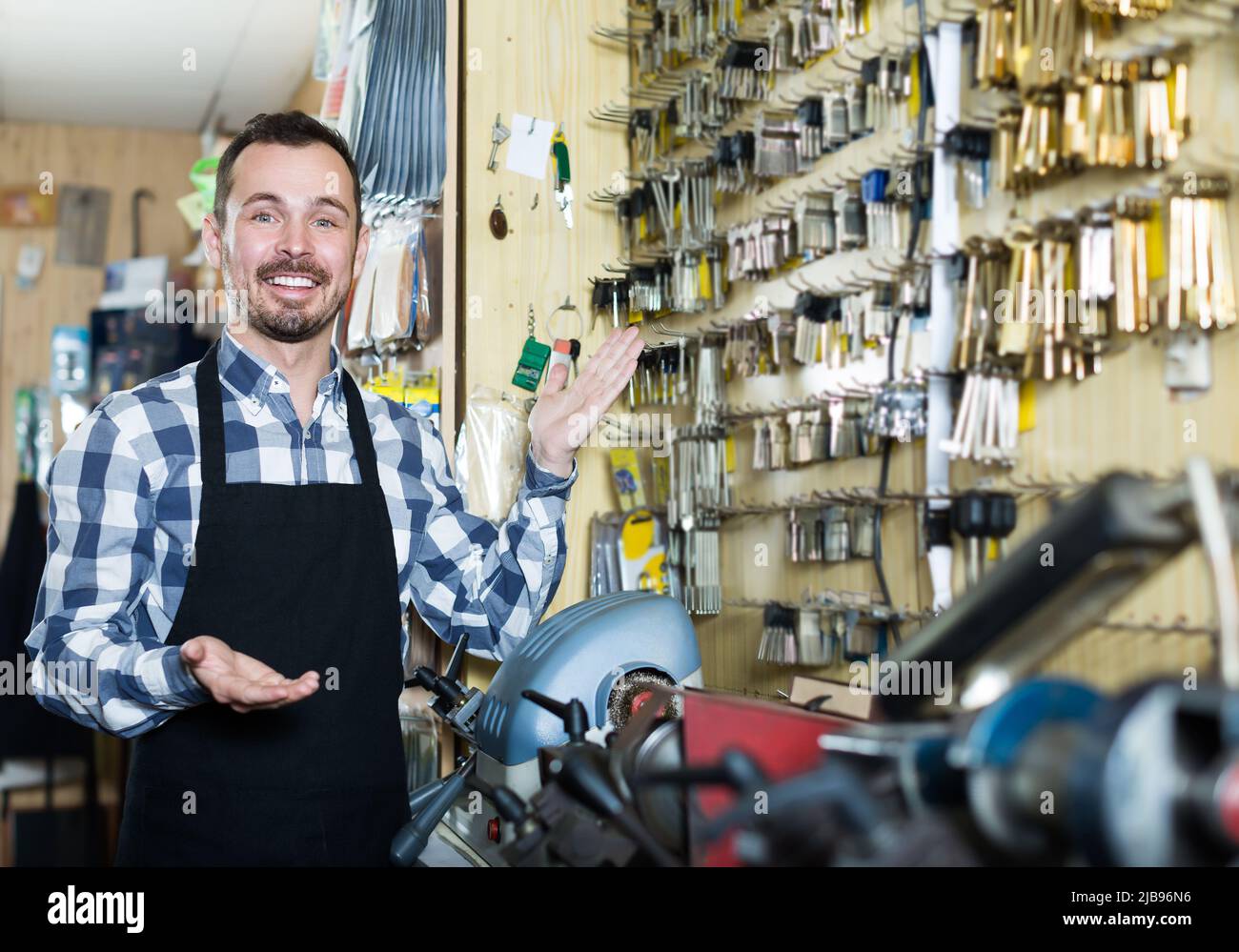 Young worker showing his tools for making keys Stock Photo - Alamy