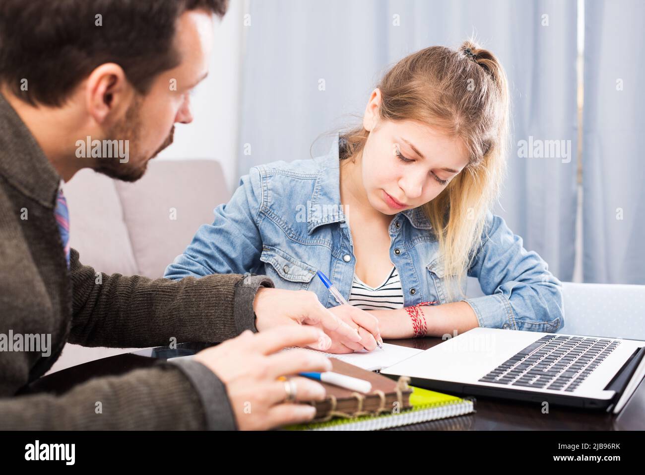 Tutor helping teenage to prepare Stock Photo - Alamy