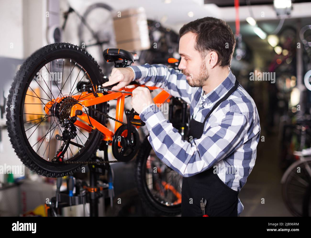 Middle-aged mechanic is working on master bicycle assembly Stock Photo ...