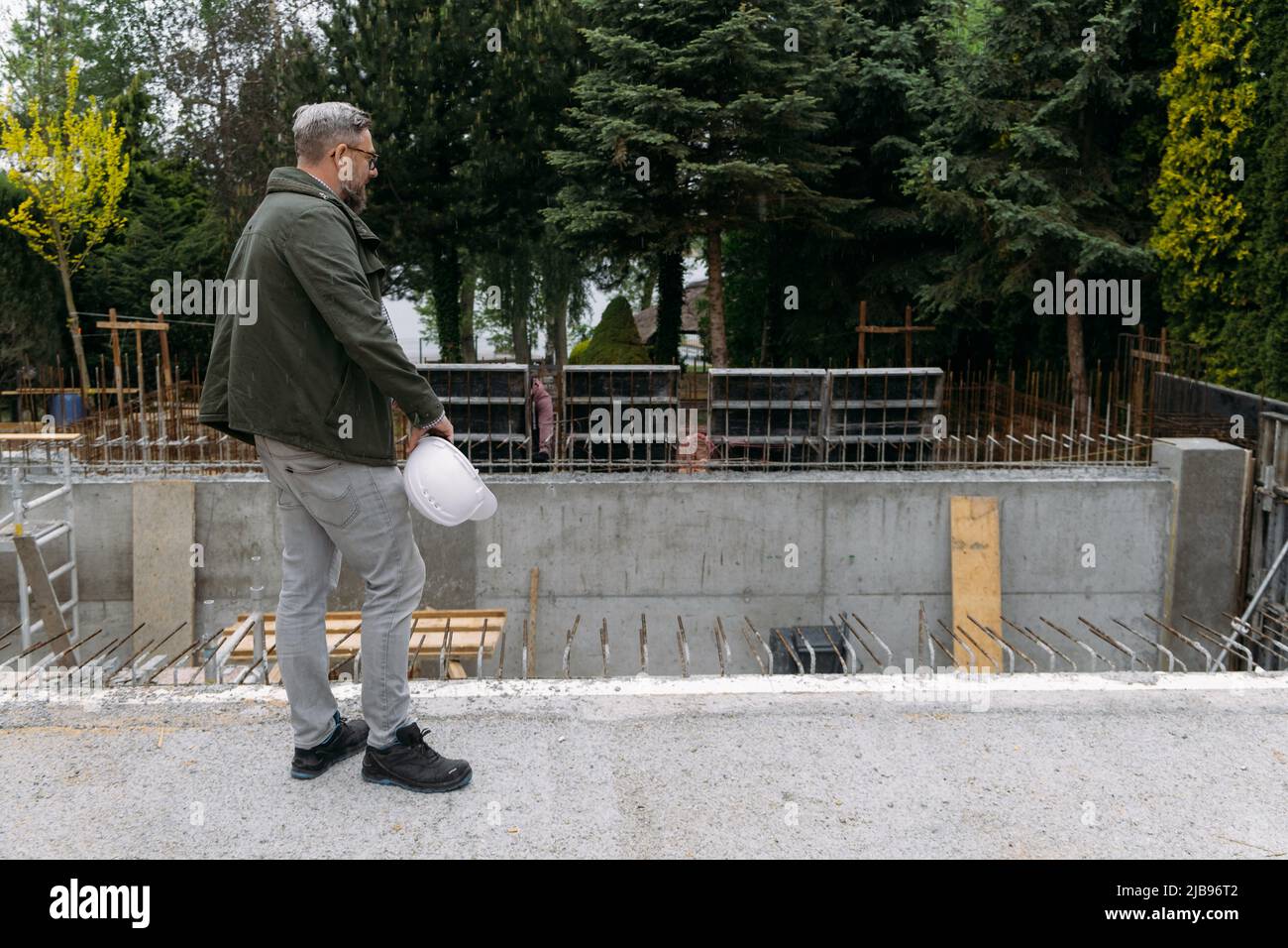 Foreman builder engineer worker looking at large building construction ...