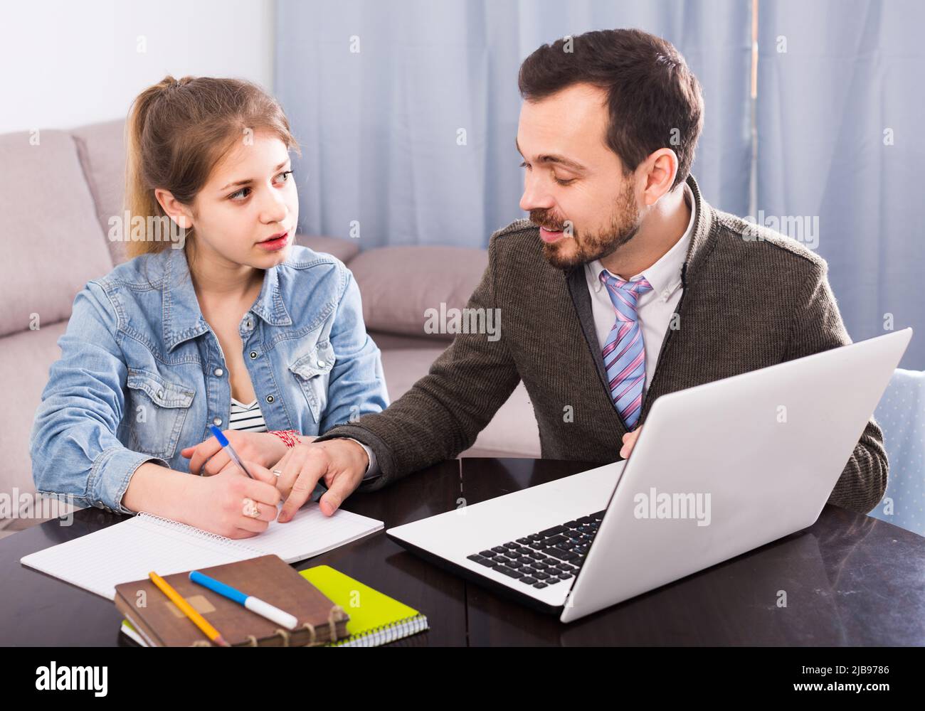 Male tutor assisting his teenage pupil to prepare for test Stock Photo ...