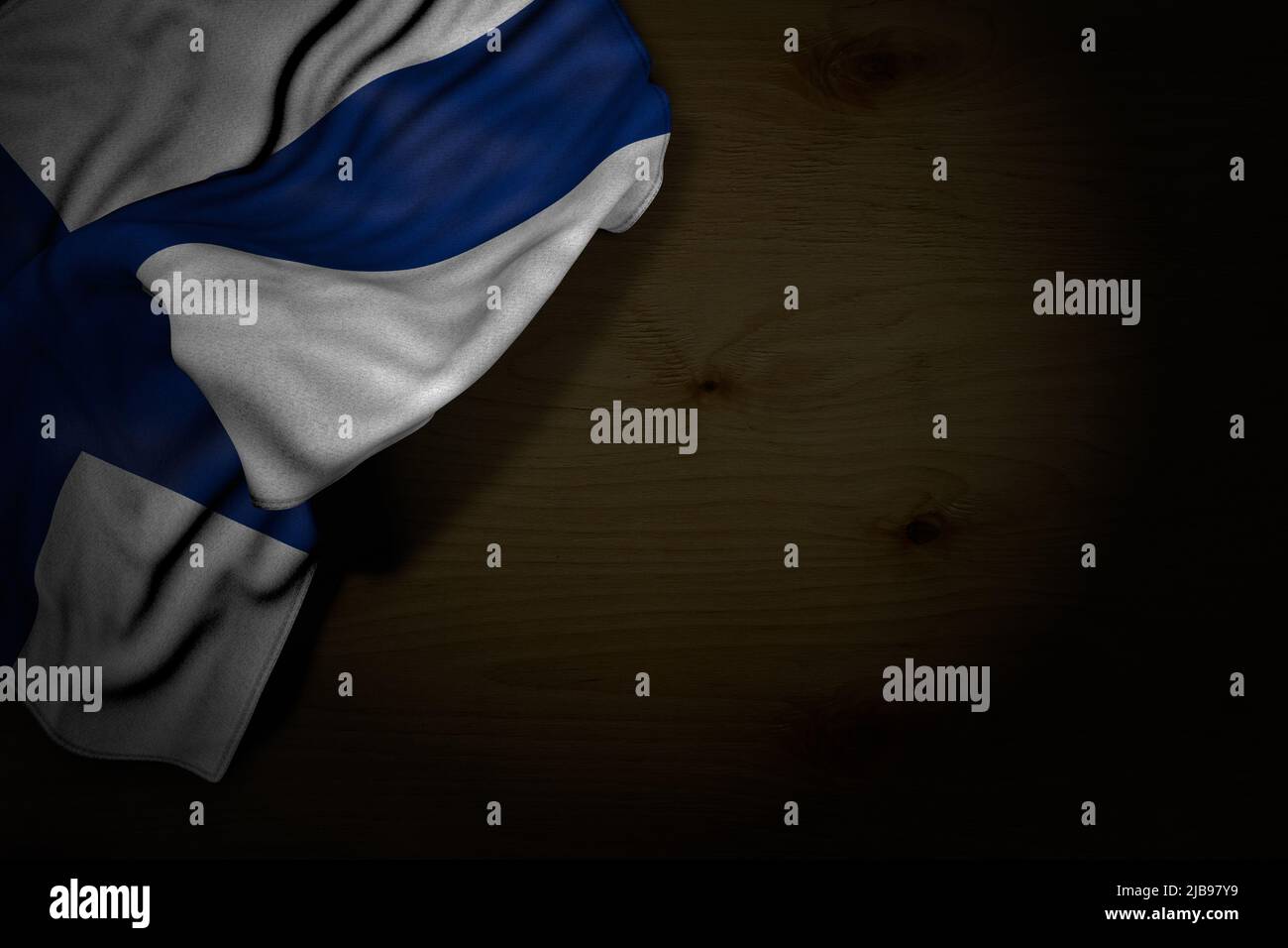 beautiful dark photo of Finland flag with big folds on dark wood with ...
