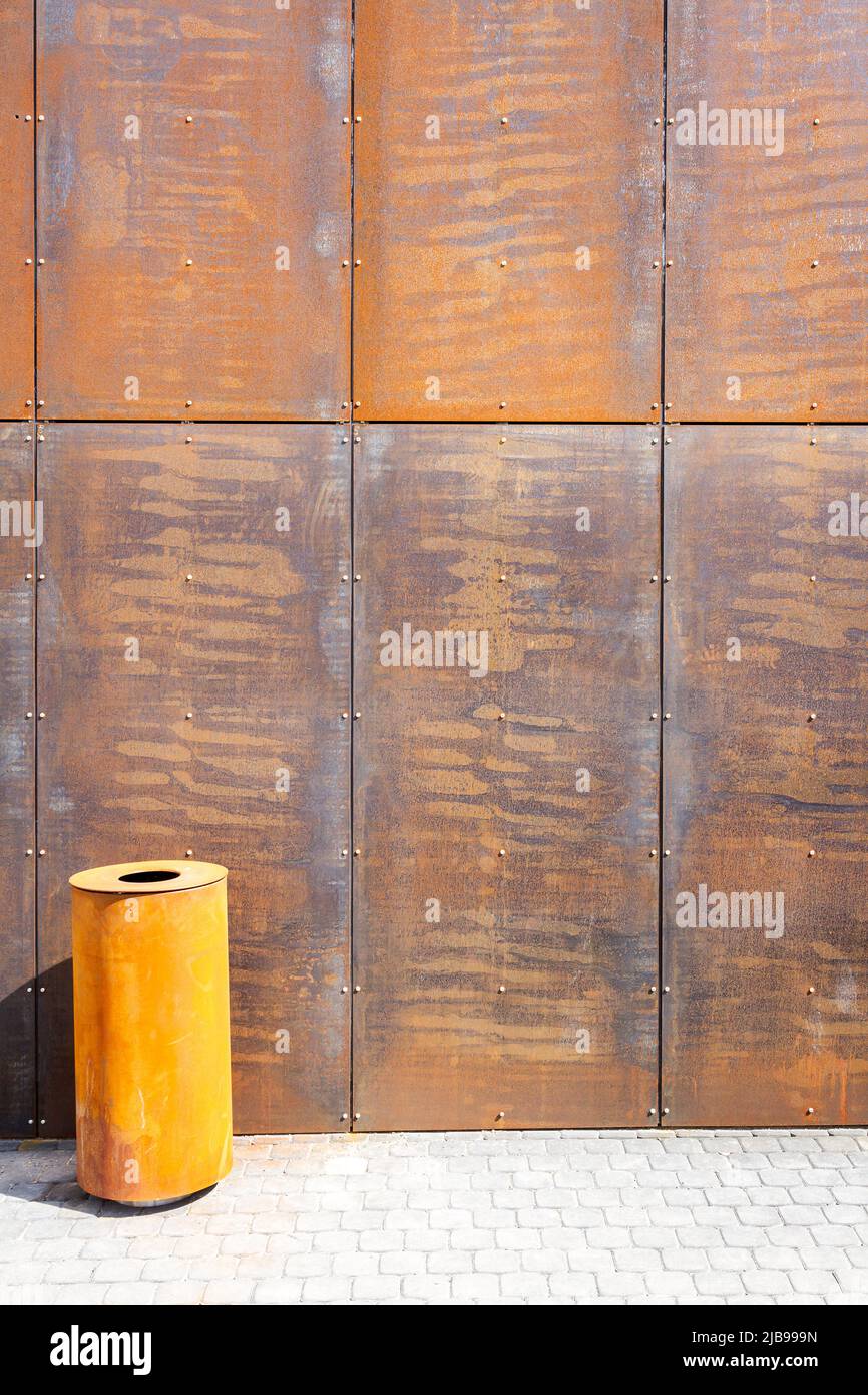 Modern architecture rusty metal wall with a bin and a sidewalk Stock ...