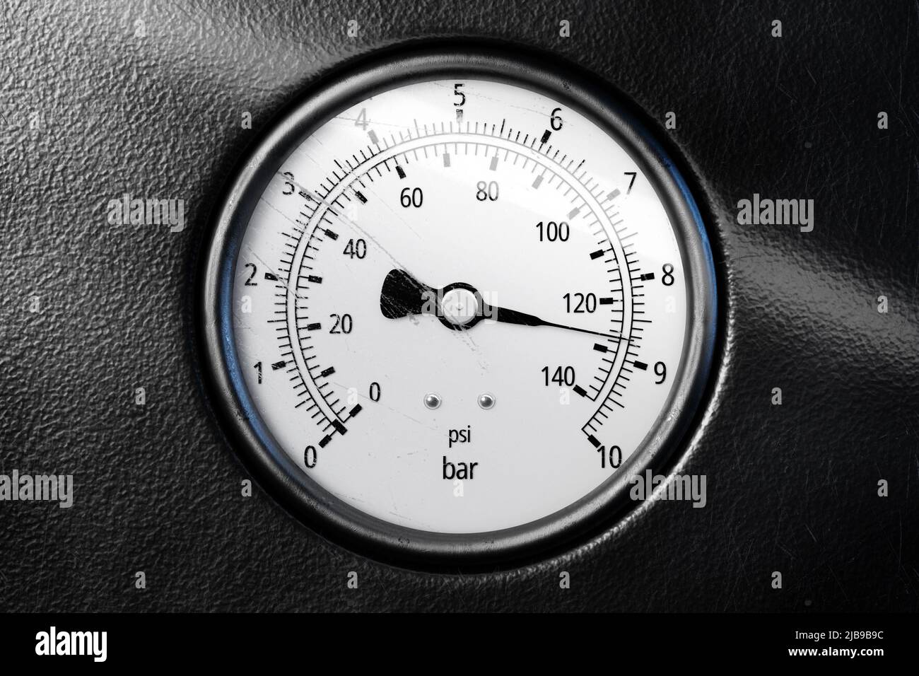 Round temperature gauge isolated on a black panel. Circular barometer ...