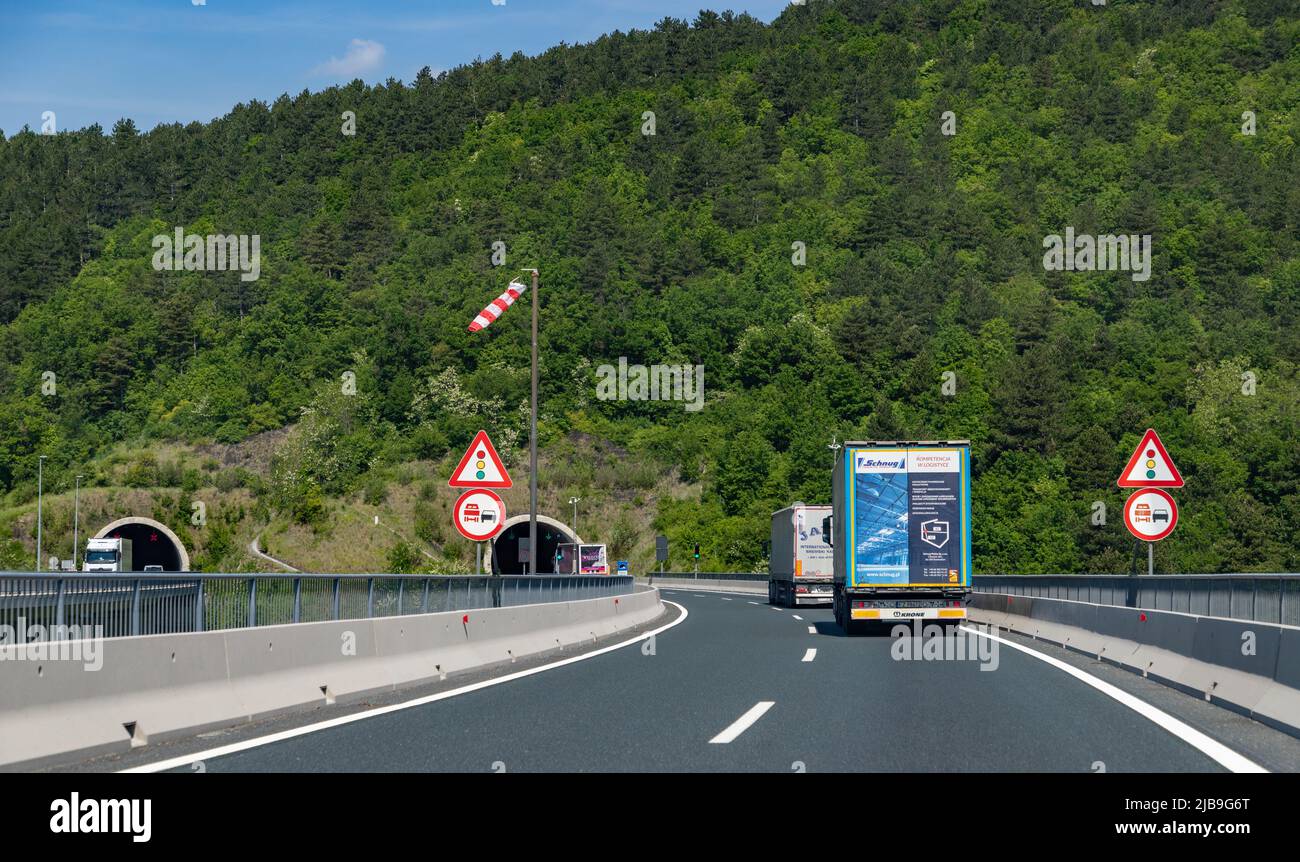 A picture of some trucks approaching a tunnel on a Slovenian highway ...