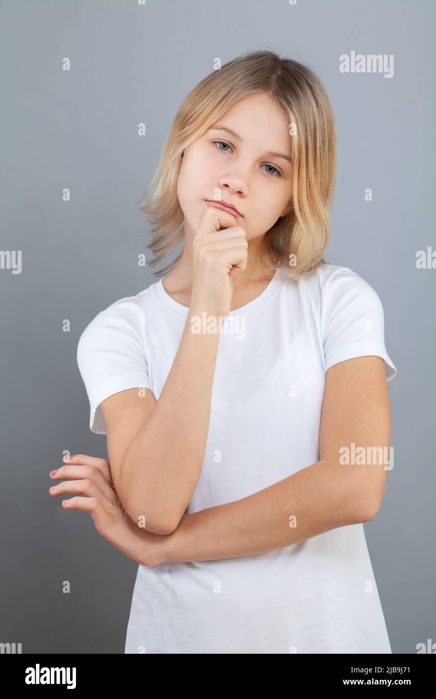 Pensive young girl thinking on gray background Stock Photo - Alamy