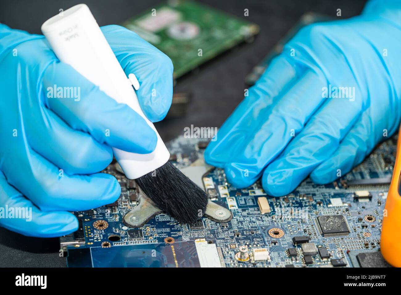 Technician use brush and air blower ball to clean dust in circuit board ...