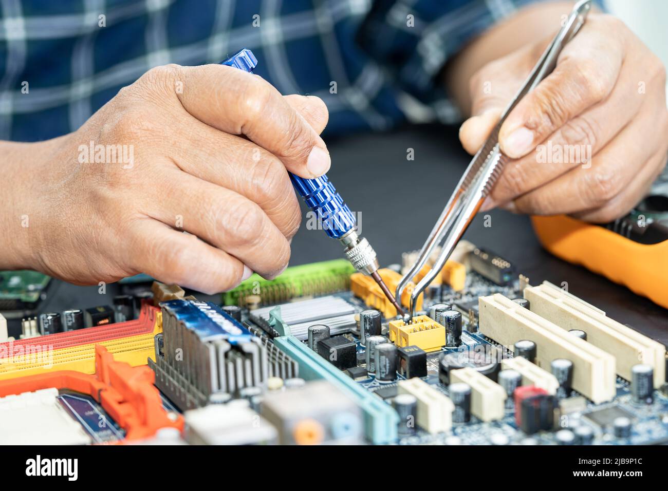 Technician repairing inside of mobile phone by soldering iron ...