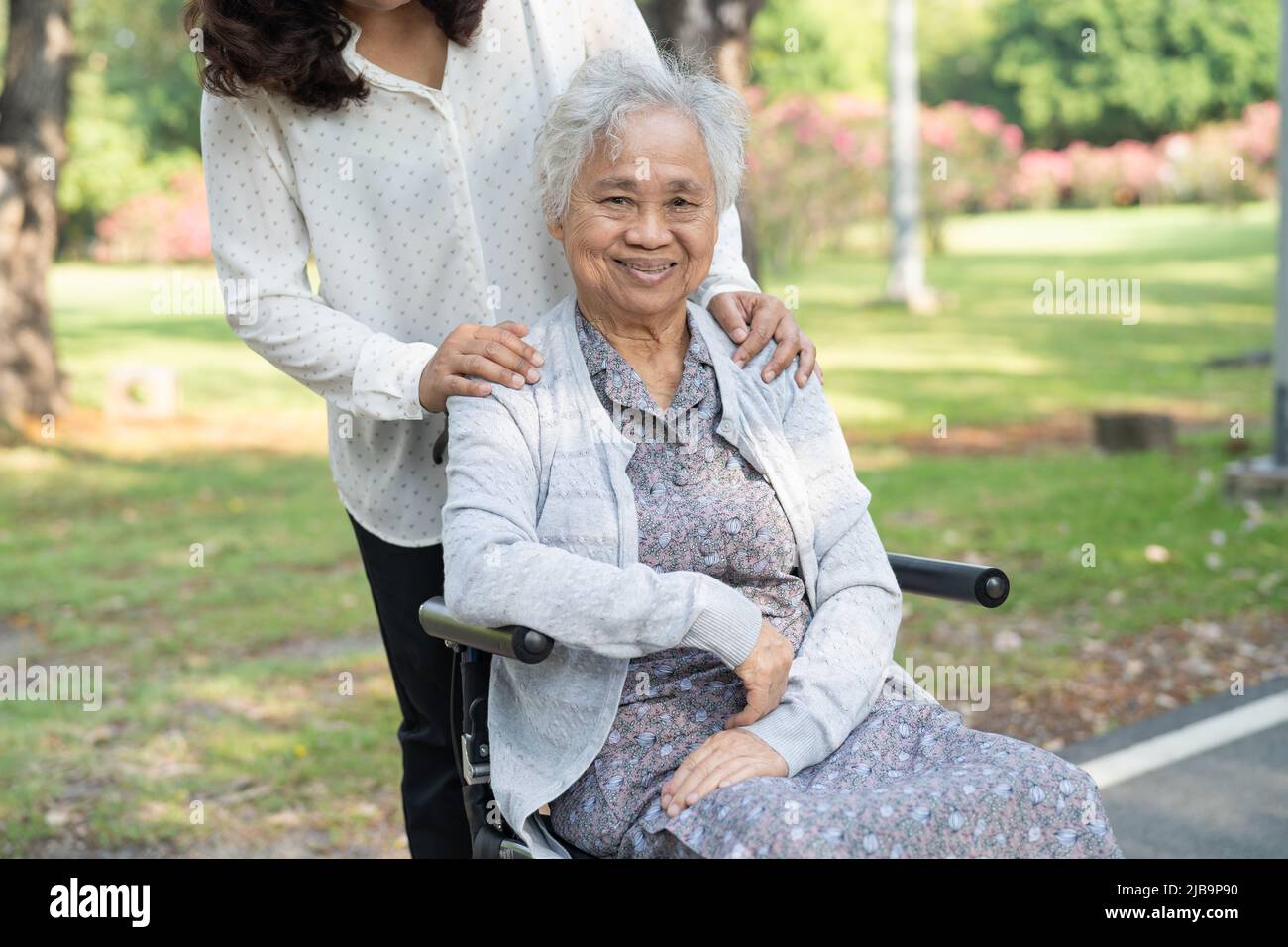 Caregiver help and care Asian senior or elderly old lady woman patient sitting and happy on ...