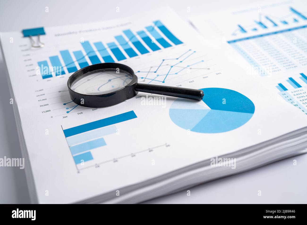 Magnifying glass on charts graphs paper. Financial development, Banking ...