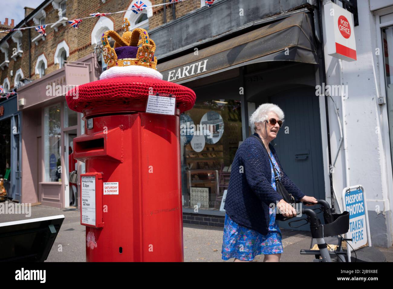 A crocheted knitted crown sits on top of a Royal Mail postal box in ...