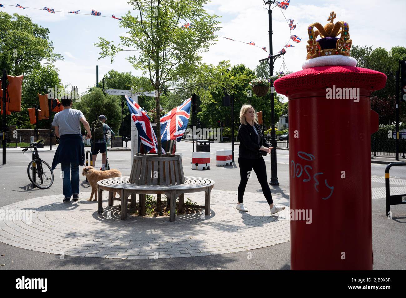 A crocheted knitted crown sits on top of a Royal Mail postal box in ...
