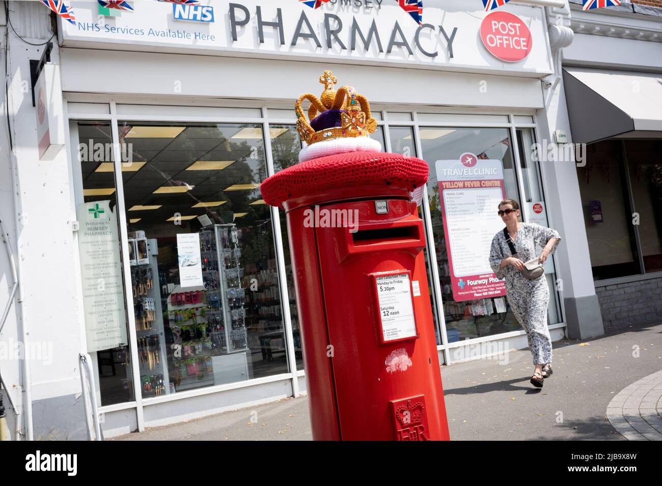 A crocheted knitted crown sits on top of a Royal Mail postal box in ...