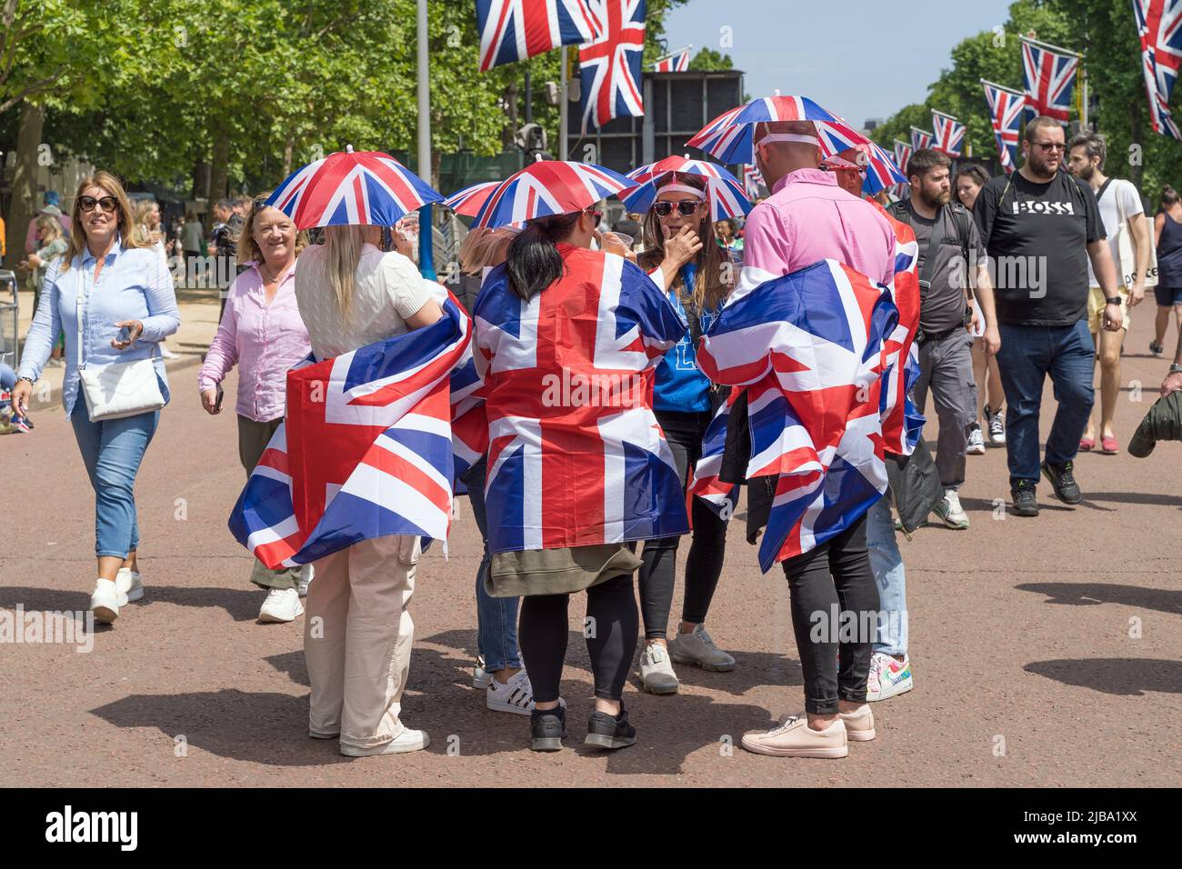Group of people down The Mall dressed up in Union Jack flags and hats ...