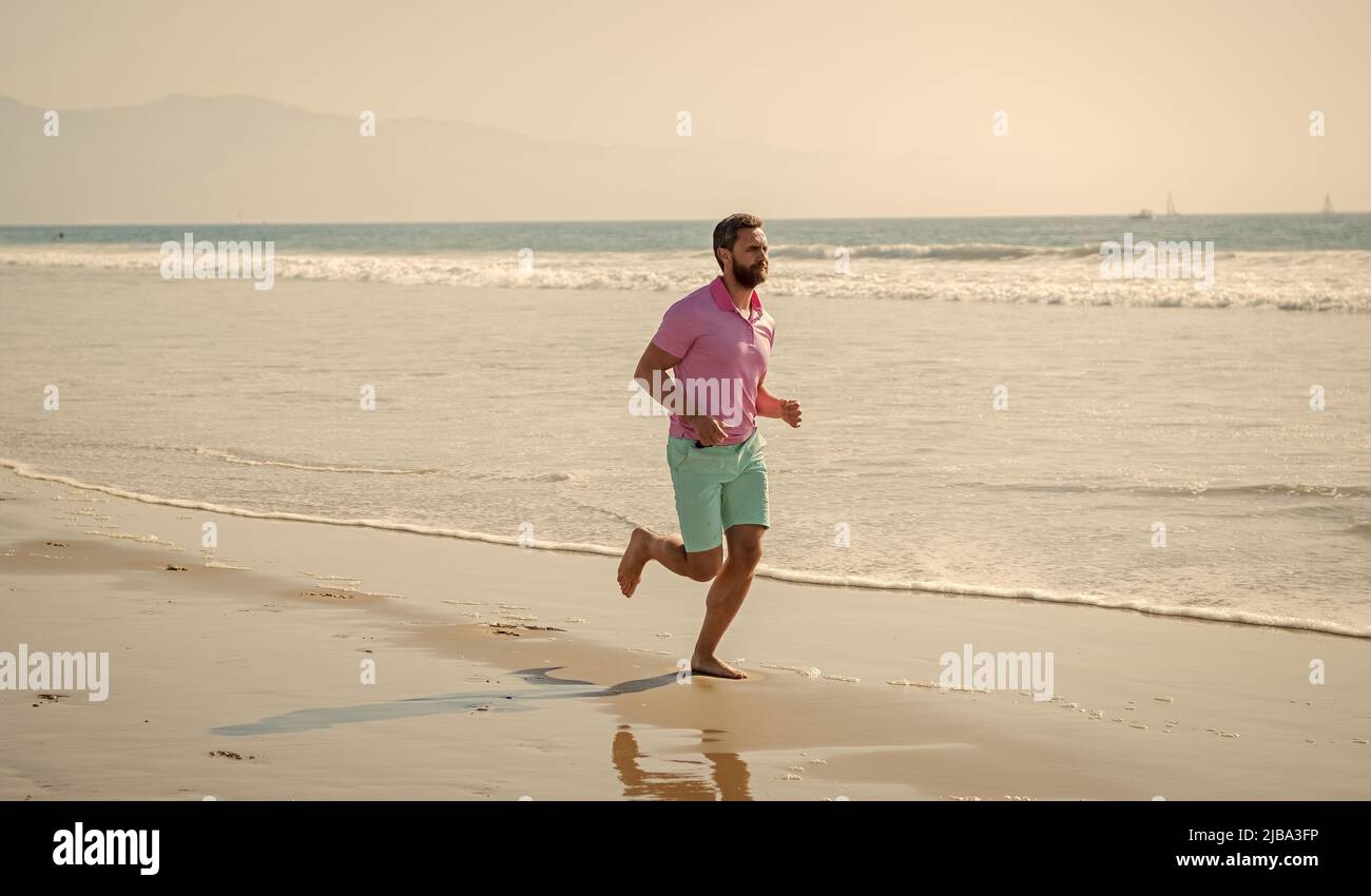 happy man runner running barefoot on summer beach, activity Stock Photo ...
