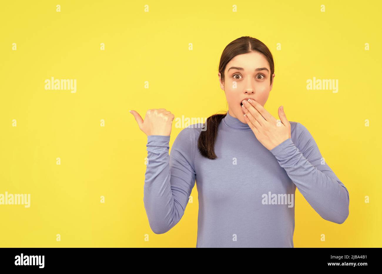 shocked woman portrait pointing fingers on copy space yellow background ...