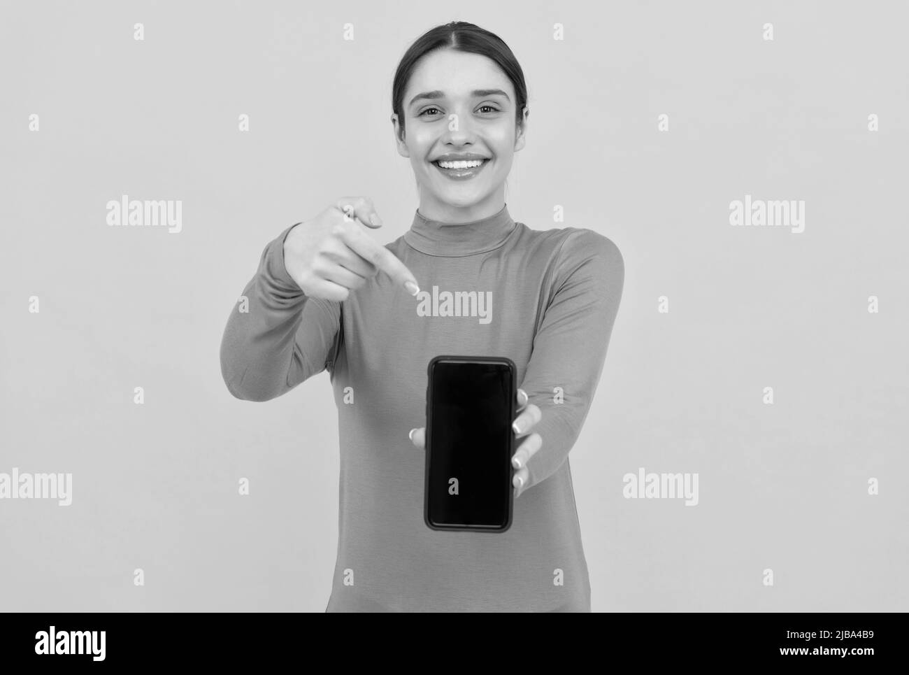 happy girl pointing finger on smartphone screen, copy space ...