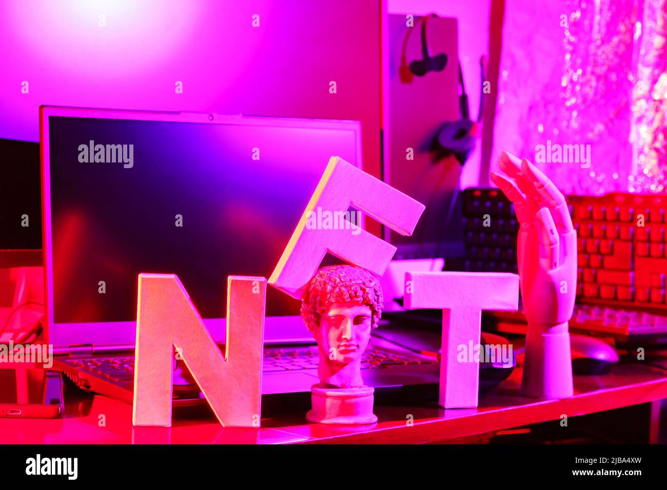 NFT (Non-Fungible Token) and computer equipment in pink neon light. NFT ...