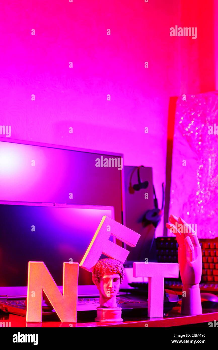 NFT (Non-Fungible Token) and computer equipment in pink neon light. NFT ...