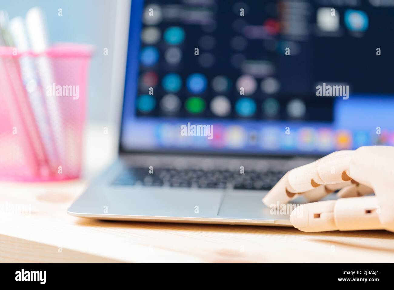 Robotic arm using laptop on a wooden table. Artificial intelligence ...