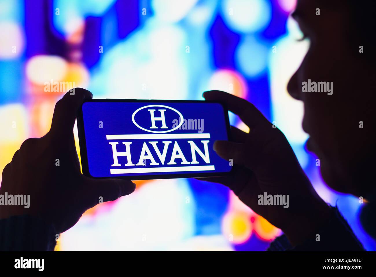 In this photo illustration, a silhouetted woman holds a smartphone with ...