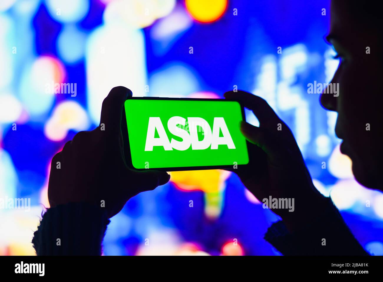 In this photo illustration, a silhouetted woman holds a smartphone with ...