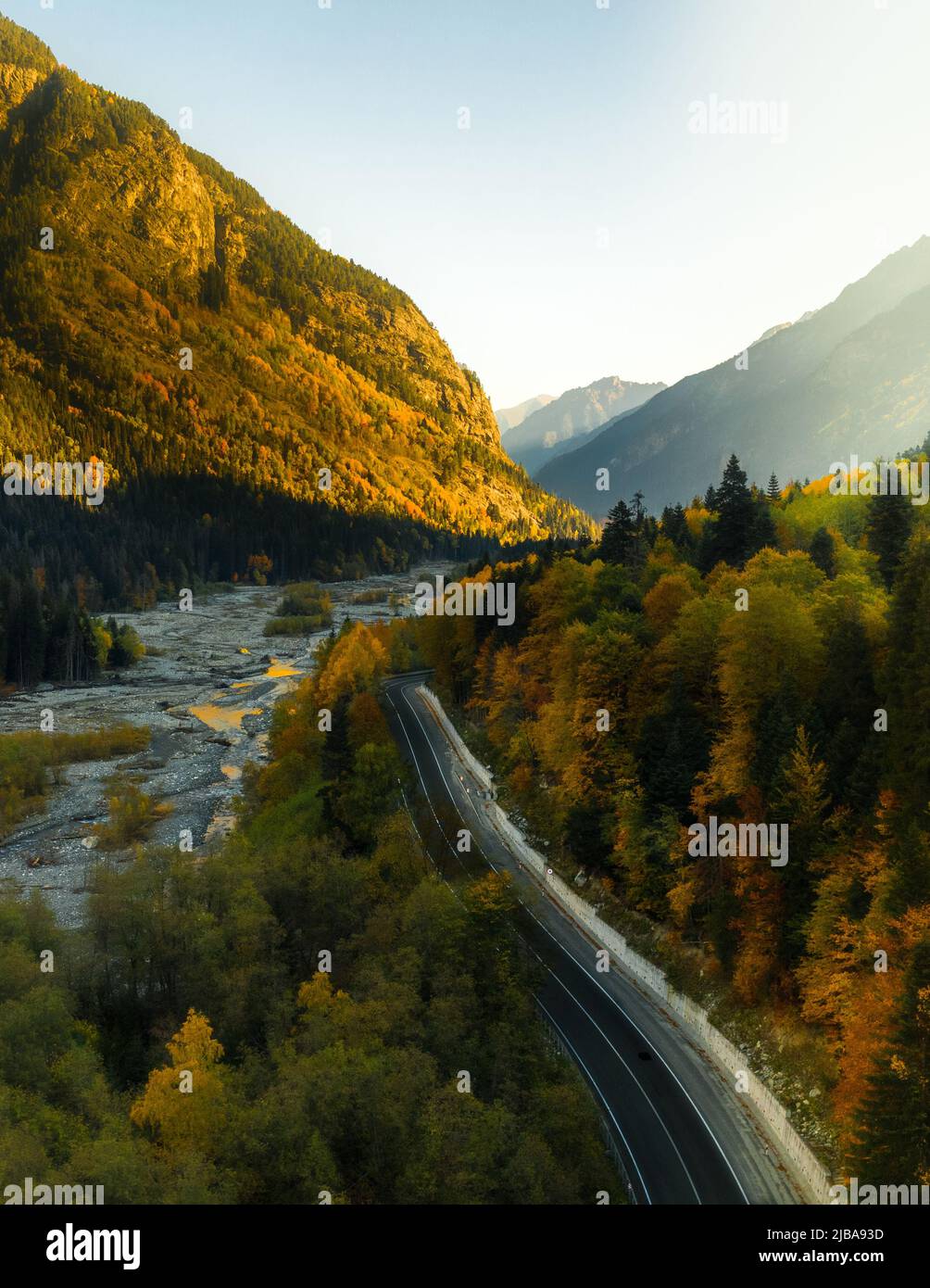 Mountain road going into the distance next to the river Stock Photo - Alamy