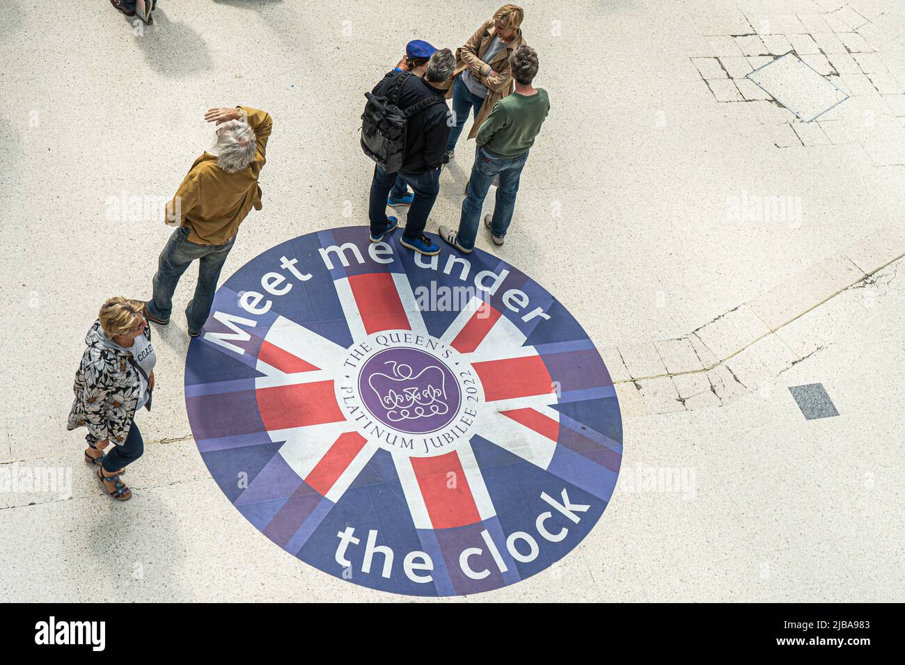 London UK, 4 June 2022. Rail passengers walk across a Platinum Jubilee ...