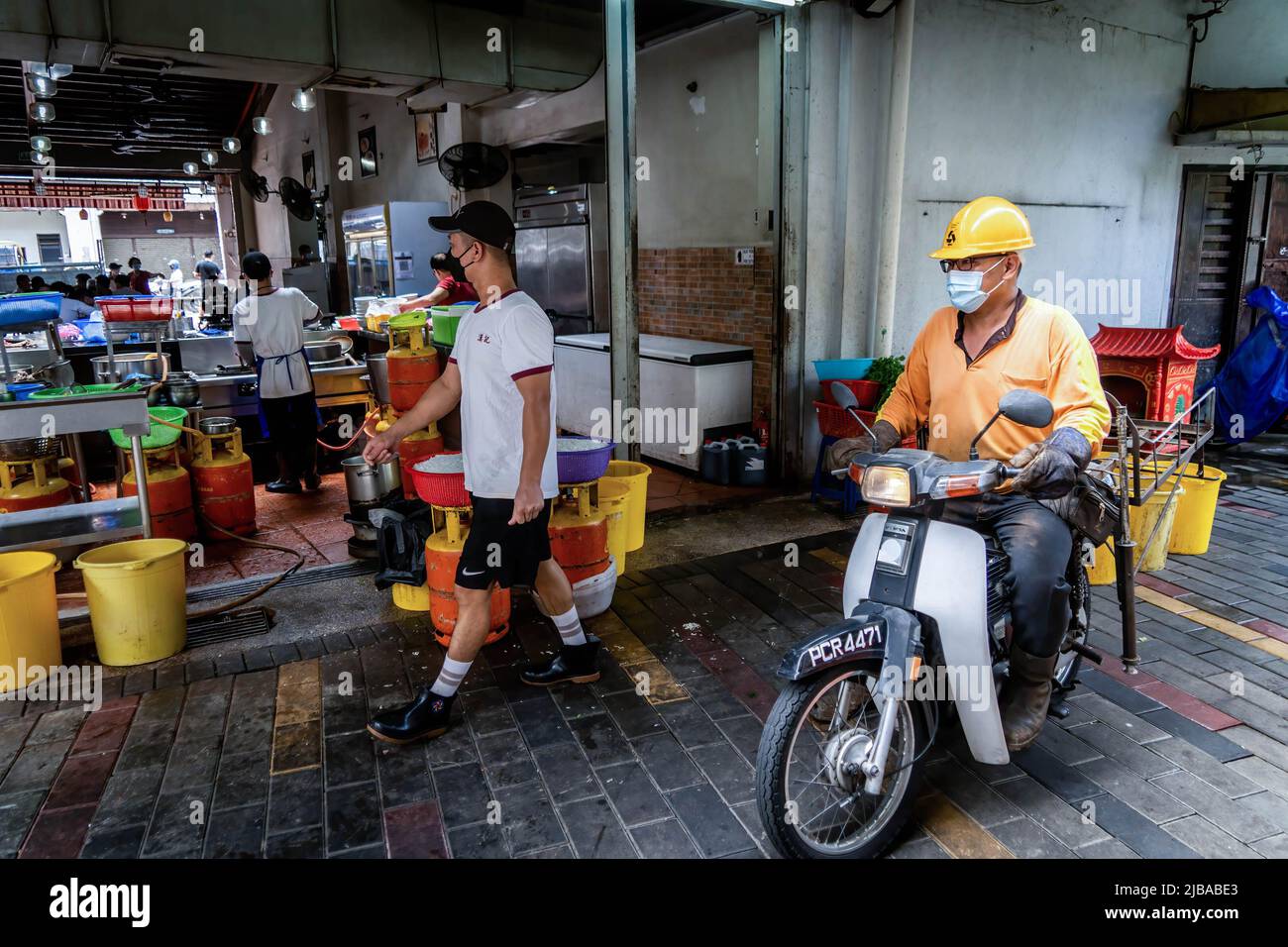 A propane salesman delivers propane tanks to street food vendors at a ...