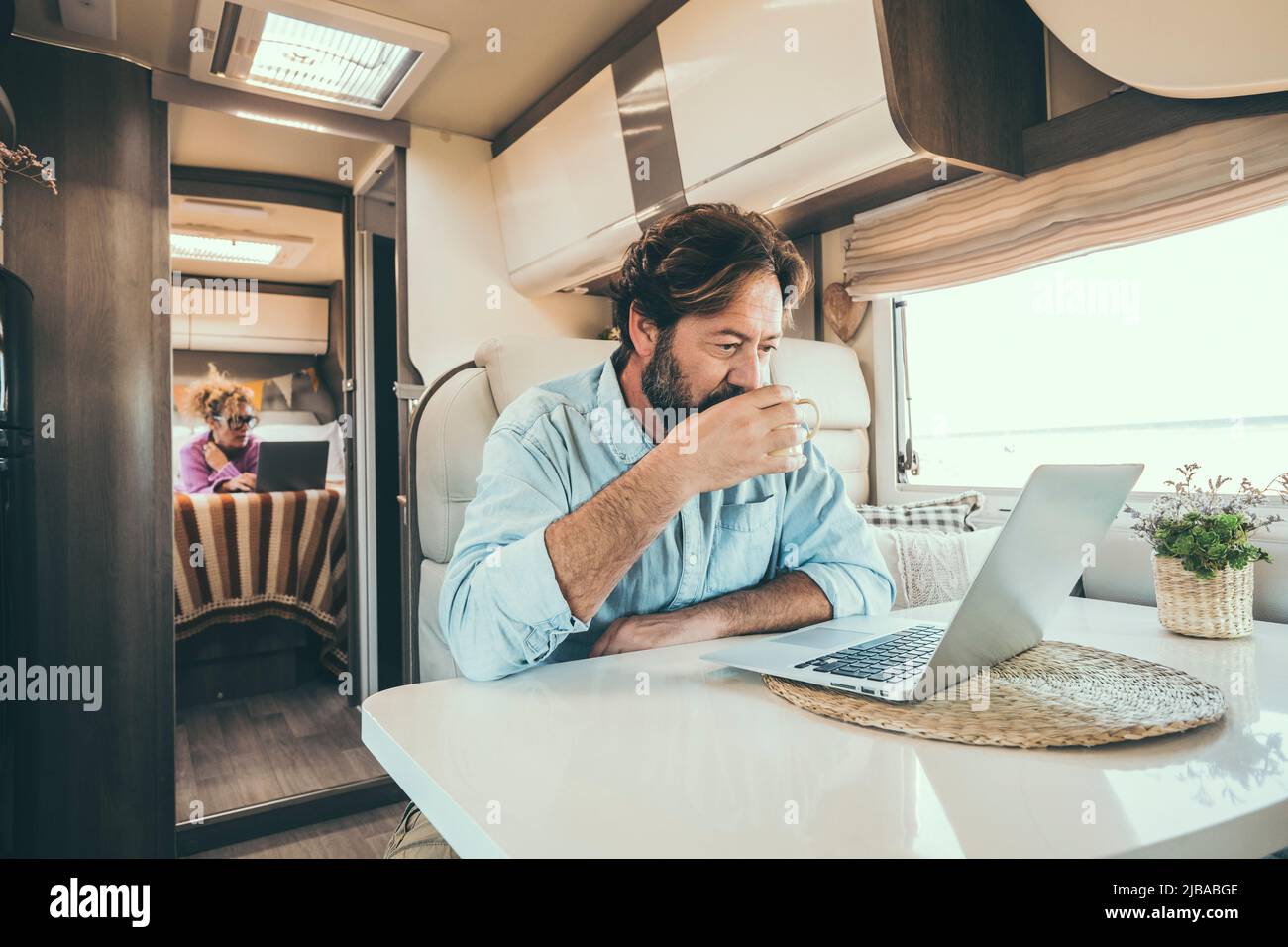 Couple use computer inside camper van during travel vacation or van ...
