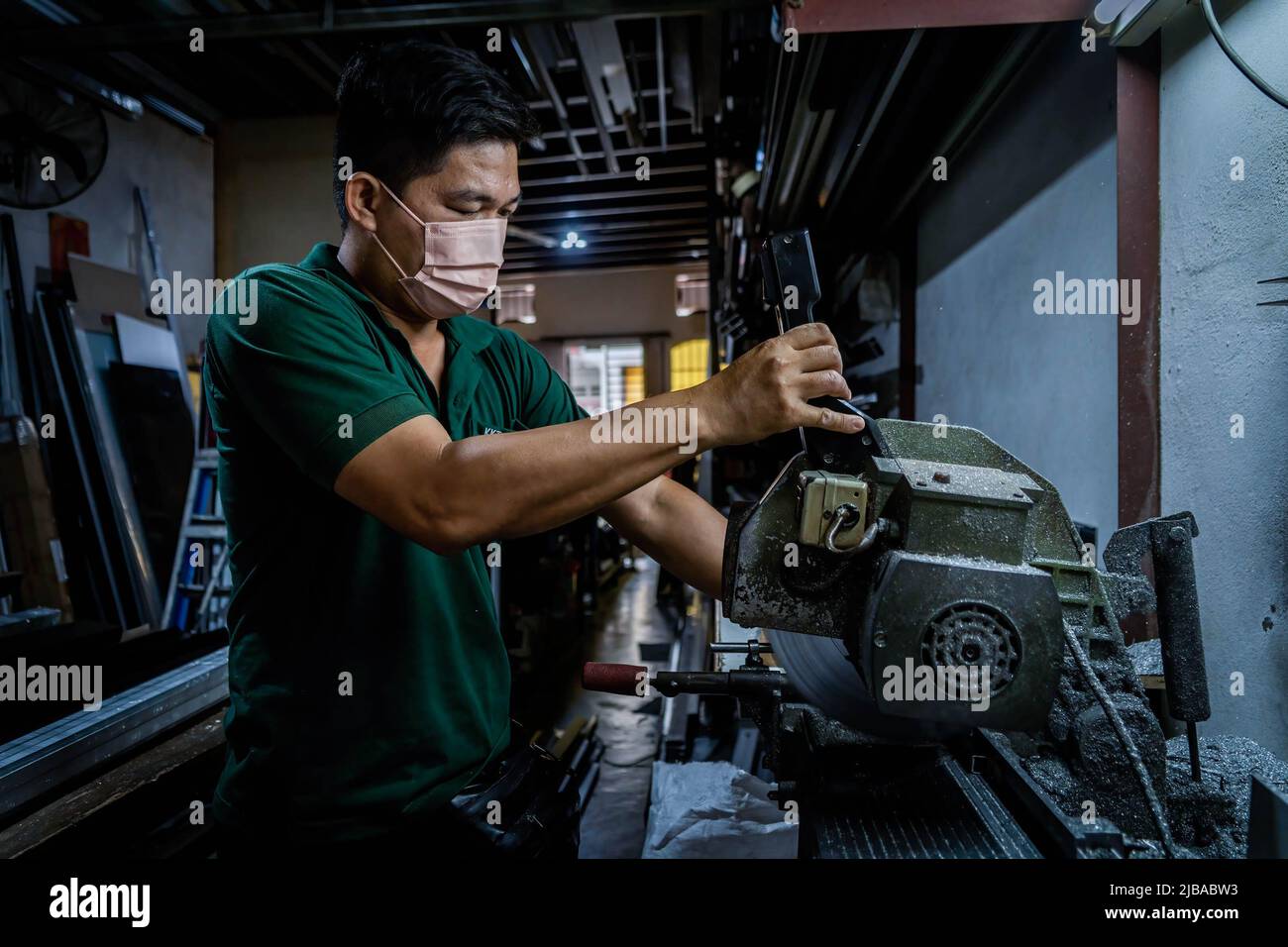 Penang, Malaysia. 4th June, 2022. A window frame maker chops metal in ...