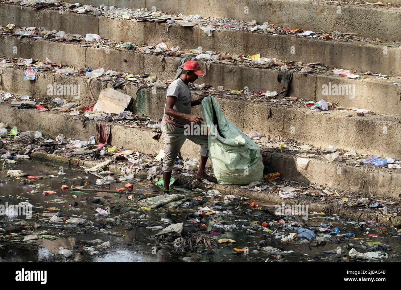 A rag picker collects usable plastics from the garbage on the eve of ...
