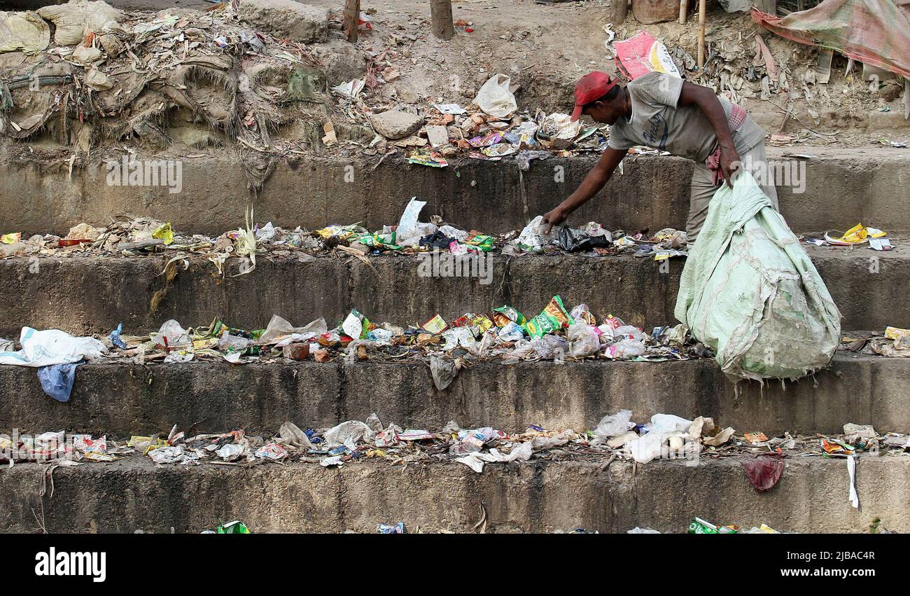 A rag picker collects usable plastics from the garbage on the eve of ...