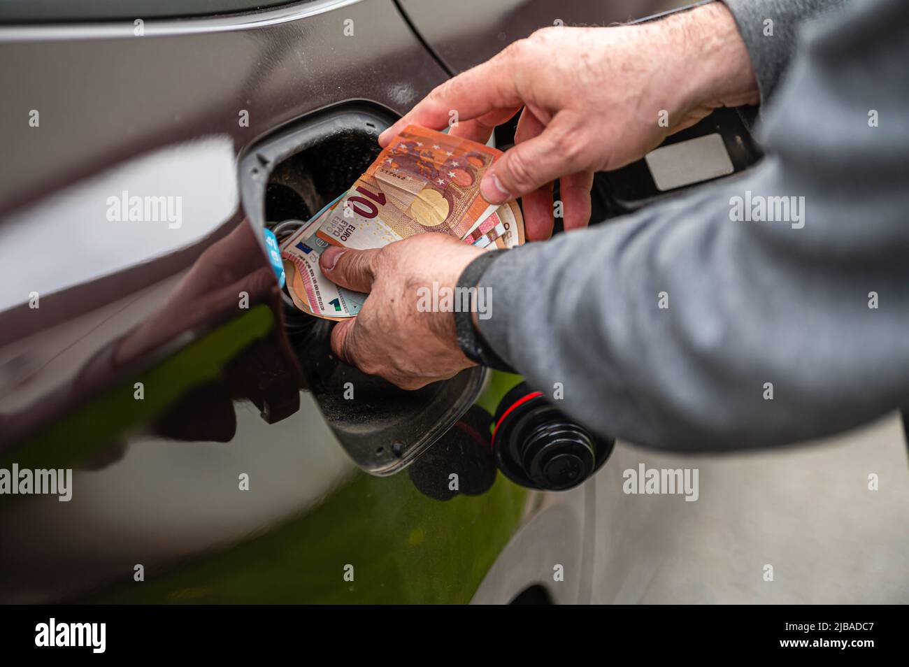 hand of man that puts money into the tank of car, close-up, concept of ...