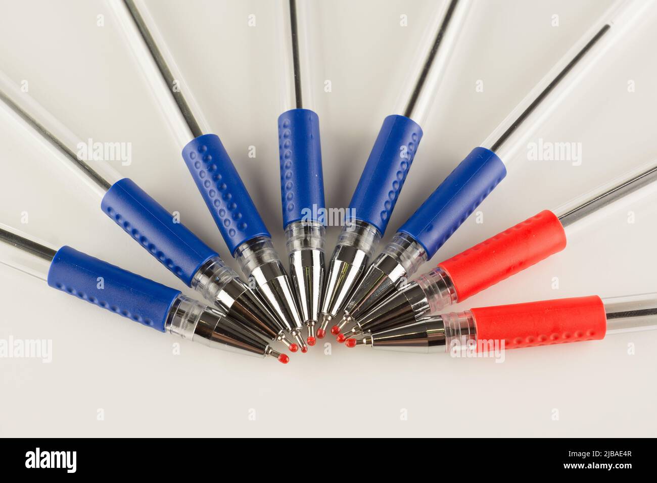 set of blue ballpoint pens lined up by an arc on a white background ...