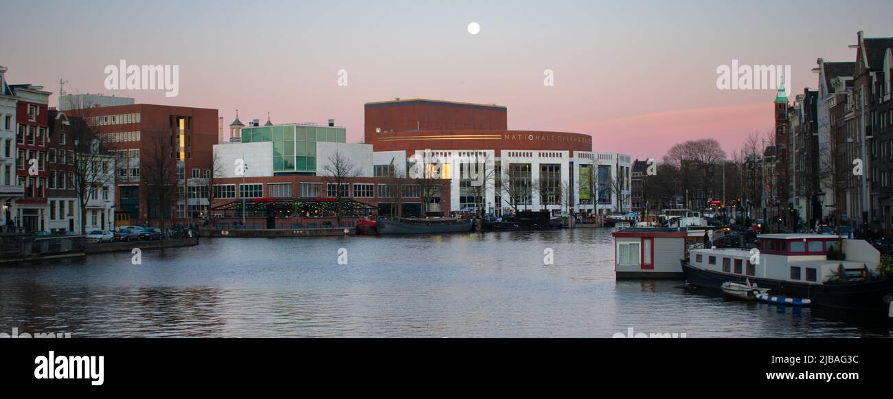 National Opera Museum in Amsterdam with full moon and Amstel river in ...