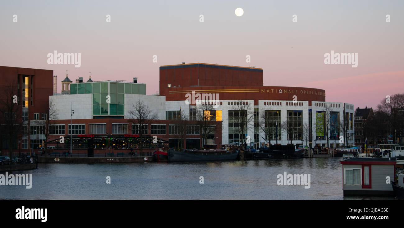 National Opera Museum in Amsterdam with full moon and Amstel river in ...