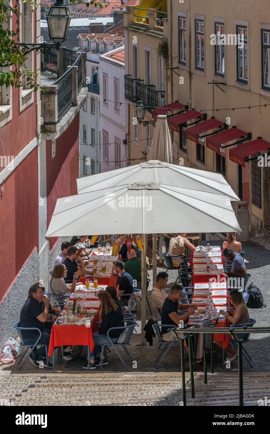 Outdoor cafe on the old streets of Alfama, Lisbon overlooking Castelo ...