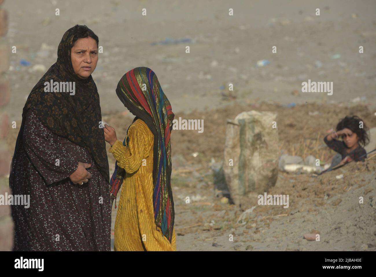 Pakistani people busy in their routine work near a garbage dump site ...