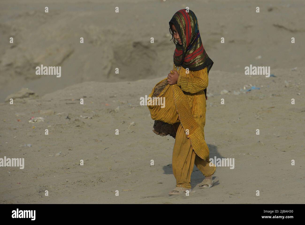 Pakistani people busy in their routine work near a garbage dump site ...