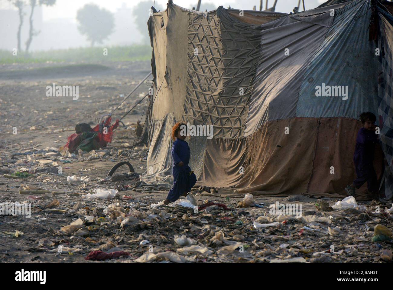 Pakistani people busy in their routine work near a garbage dump site ...