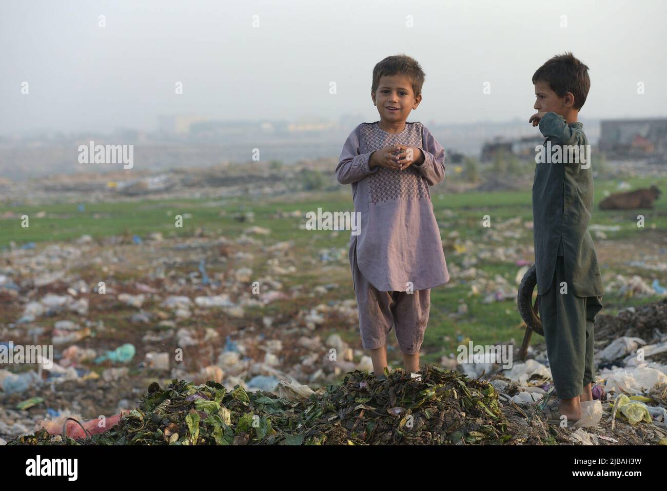 Pakistani people busy in their routine work near a garbage dump site ...