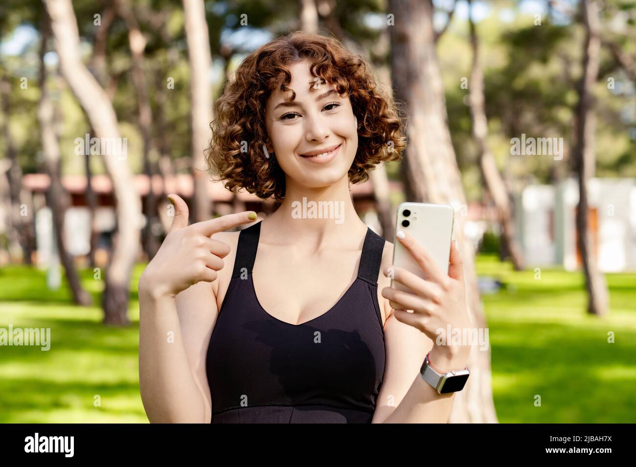 Cute redhead woman wearing sports bra standing on city park, outdoors ...