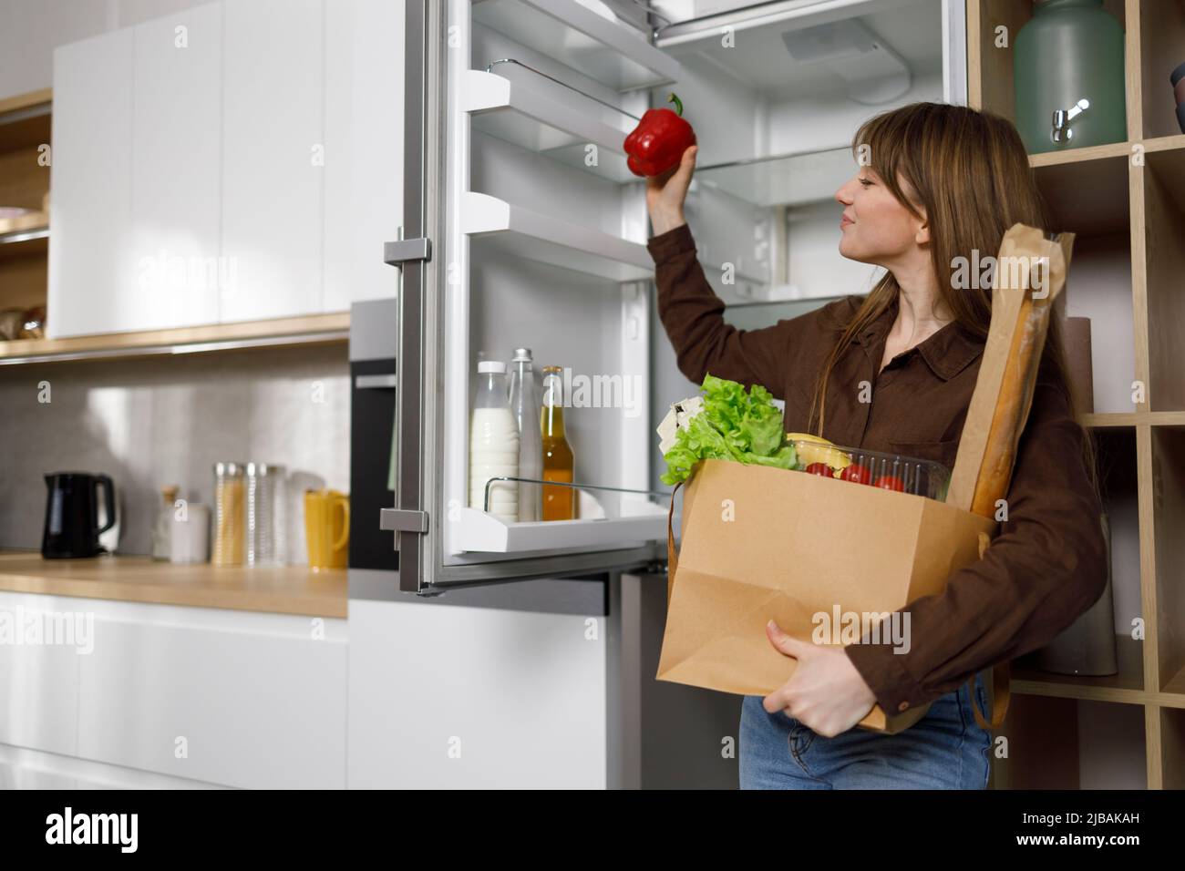 Woman putting food in fridge hi-res stock photography and images - Alamy