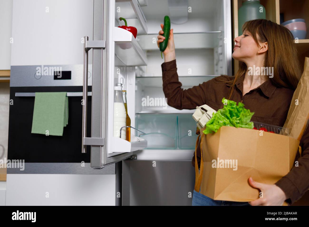 Woman putting food in fridge hi-res stock photography and images - Alamy